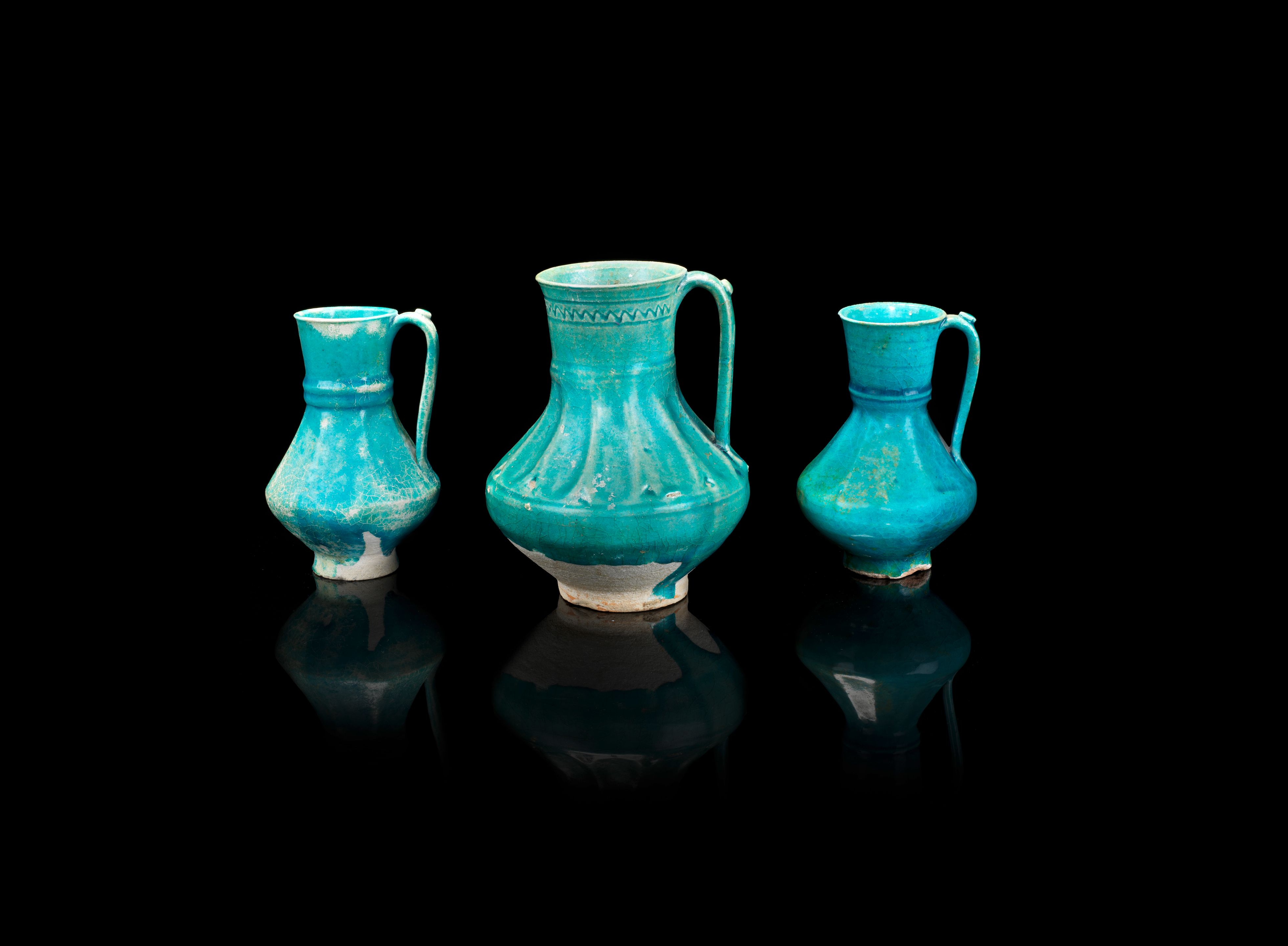 Bonhams : Three moulded monochrome pottery Jugs Persia, 12th Century(3)